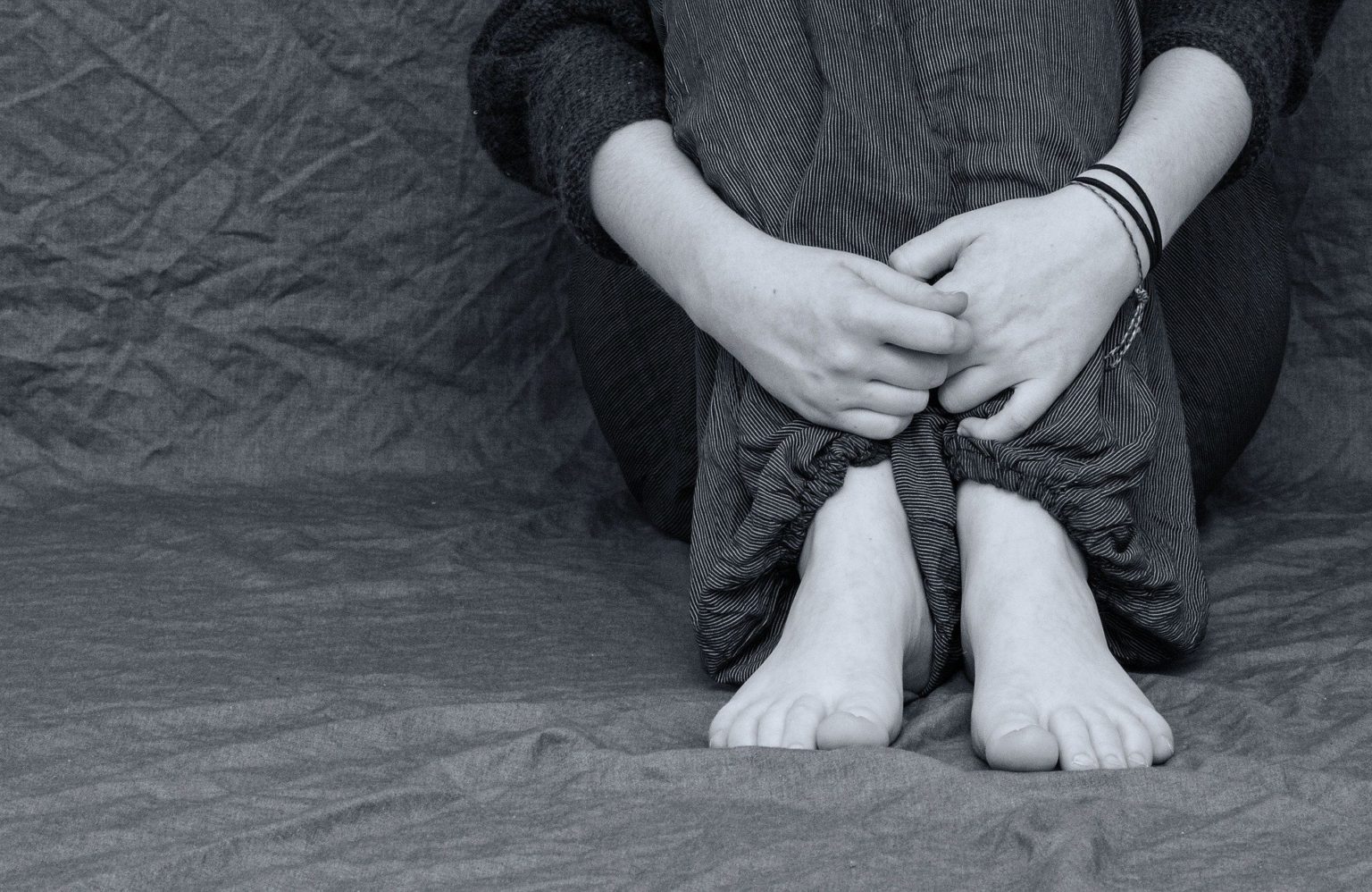 kid with arms wrapped around legs bw | Blackbird
